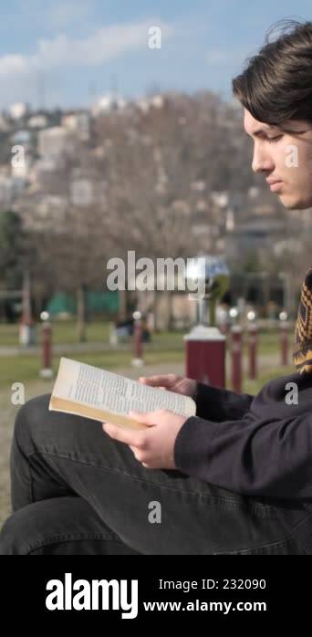 Image of lonely man reading a book on the grass, reading a novel on the ...