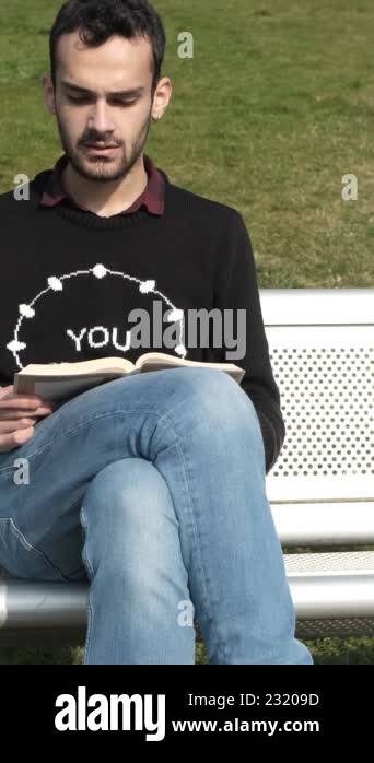 Image of lonely man reading novel on white bench in sunny day ...