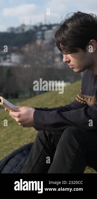 Image of lonely man reading a book on the grass, reading a novel on the ...