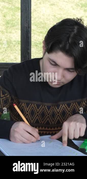 Image of lonely man studying in park, young man doing homework in ...