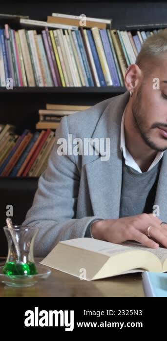 Concept of young man carefully reading a book with his back to the ...