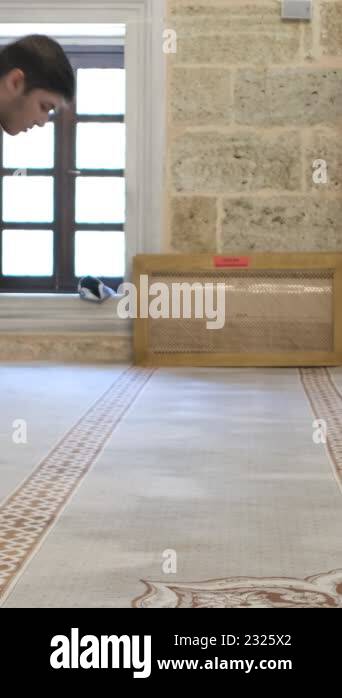 Muslim man praying in a mosque, bowing on his knees, performing ruku ...