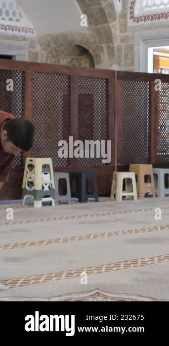 Muslim man praying in a mosque, bowing on his knees, performing ruku ...