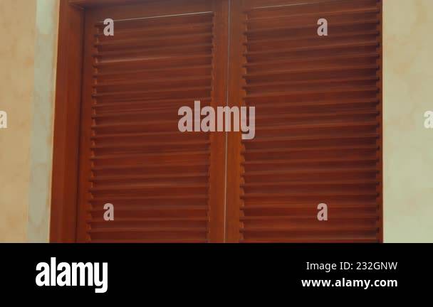 A close-up view of wooden shutters with horizontal slats, showcasing a ...