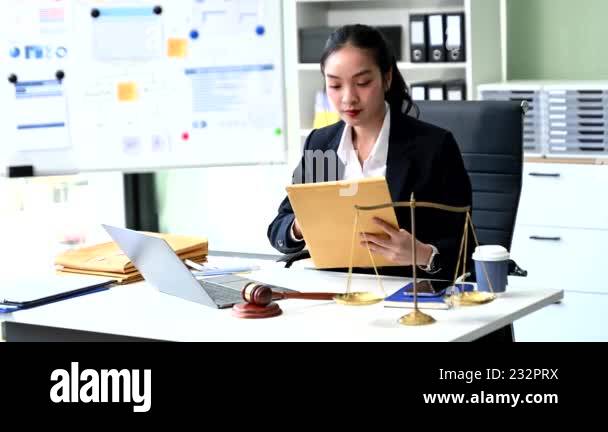 Professional female lawyer working on laptop computer and documents at ...