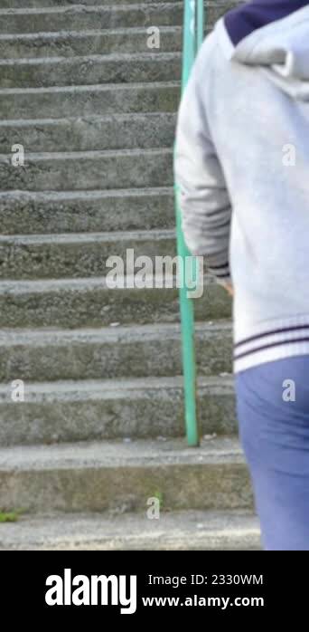 A different-angle view of the legs of a young man going upstairs, a man ...