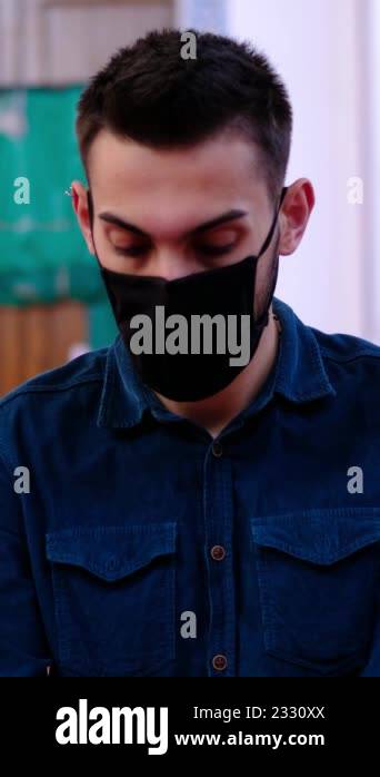 Young man with a health mask on his face ends the prayer by bowing his ...