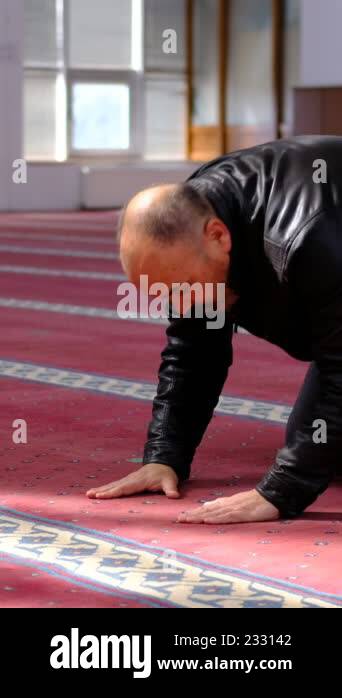 Mature man praying in a mosque taking his forehead to prostration from ...