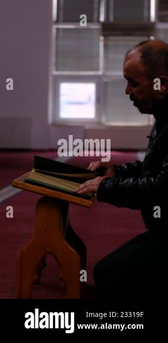 Mature man reading the holy book of islam shot from different angle ...