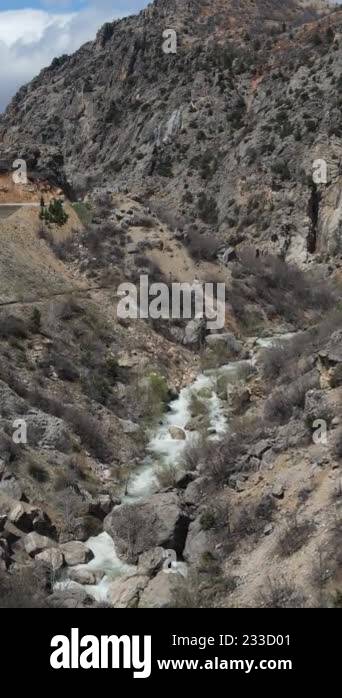 Drone view of the waterfall pouring into the valley, the stream and ...