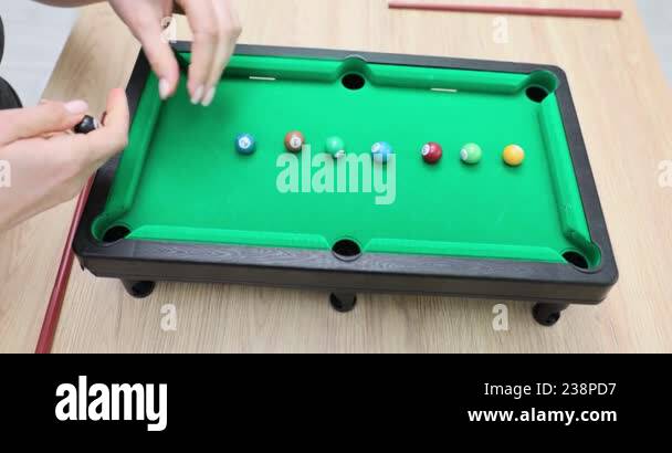 Miniature pool game showing balls in a row on green felt. Play ...