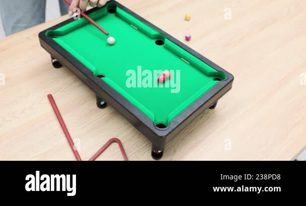 Home game of billiards is played on a table. Ball is hit with cue Stock ...