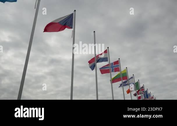 A row of flags from different countries are flying in the sky. The ...