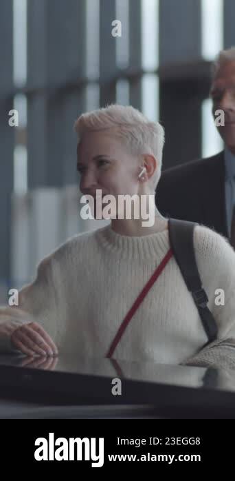 Vertical shot of passengers walking one by one to service desk at ...