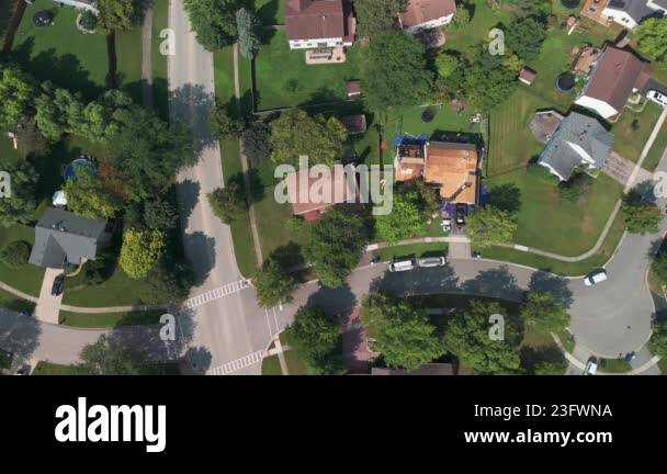 Roofers installing a new roof on an residential building. Wide aerial ...