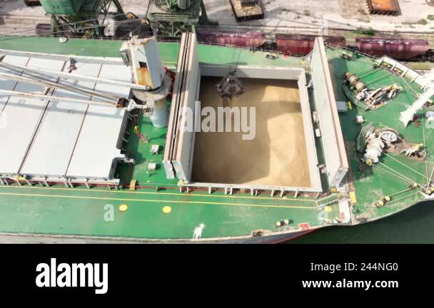 Loading dry cargo ship of wheat by cranes in port. Aerial view loading ...