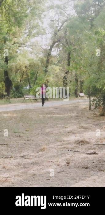 Female venezuelan athlete running through forest park, navigating ...
