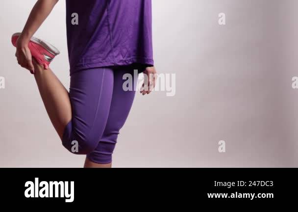 Muscular latin sportswoman stretching leg muscles in purple pink shoes ...