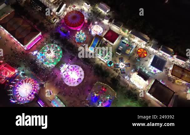 Carnival midway with colorful lights, rides, and attractions at night ...