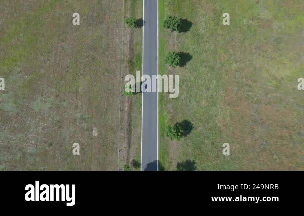 Aerial view of an empty asphalt road crossing a countryside landscape ...