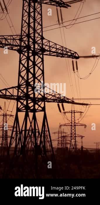 Electricity tower with wires at sunset. Tall pylon carries wires that ...