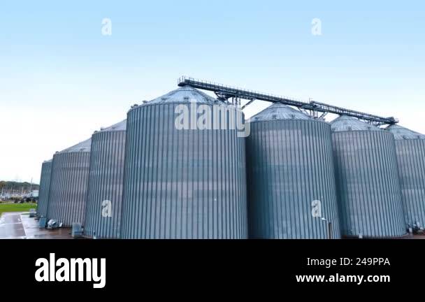 Distancing from stainless steel tanks standing in the rows. Huge silo elevators for grain ...