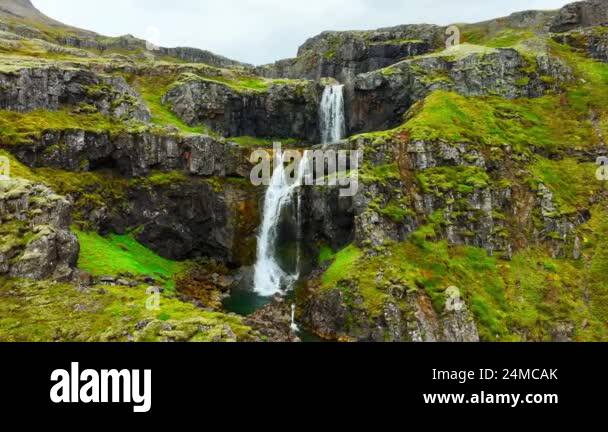 Wispy waterfalls flowing over cliff, Mountain river falling over cliff ...