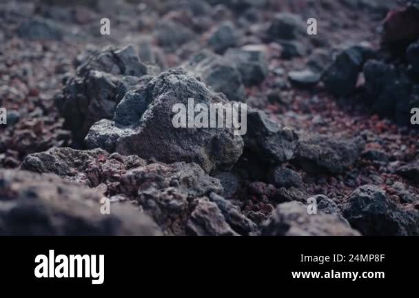 Detailed close-up of volcanic rocks scattered across a rugged and rocky ...