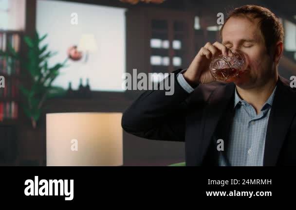 Classy high society member enjoying a glass of whiskey bourbon in a ...