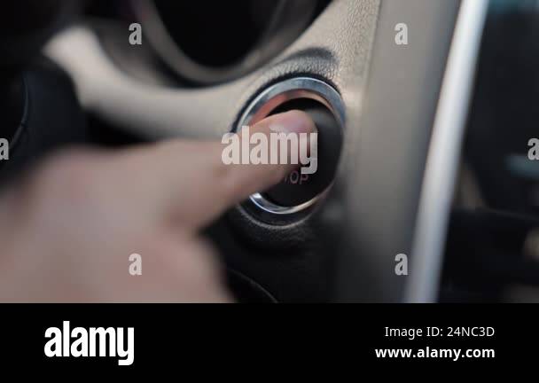Unrecognizable male driver pushing start ignition button switch in ...