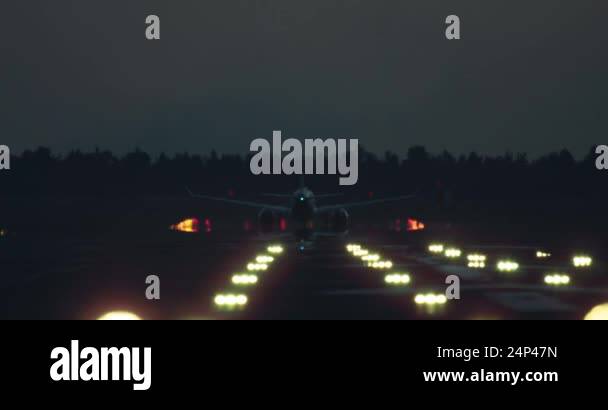 The plane takes off from the runway illuminated at night from the ...