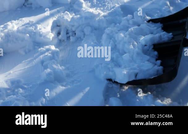 Winter landscape captures woman shoveling snow with intense effort ...