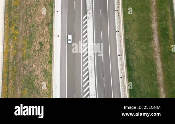 An aerial perspective showing two cars moving on a divided twolane ...