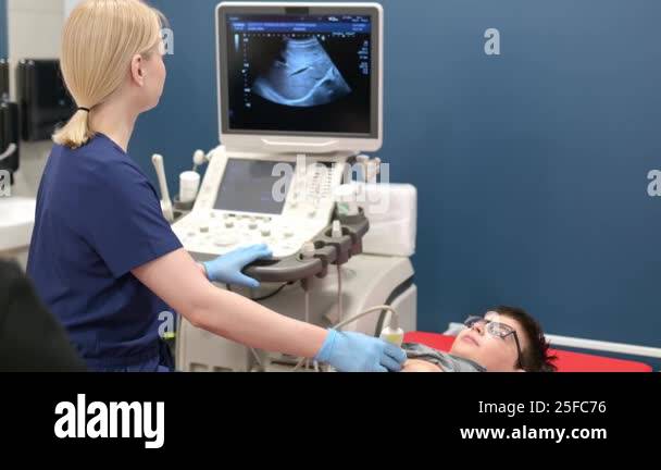 Doctor making abdominal ultrasound for boy using scanner machine ...