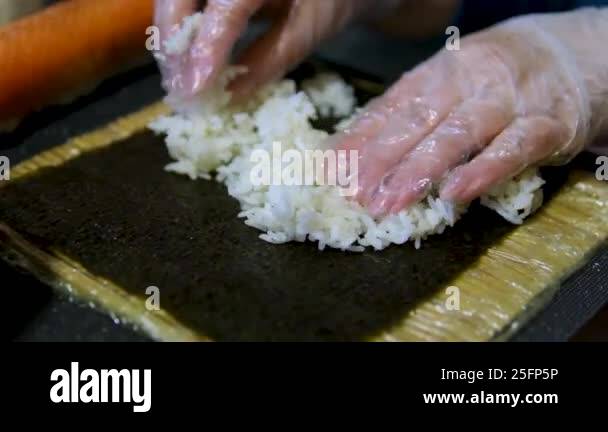 Sushi making footage. Seaweed. Chef with black gloves prepares seafood ...
