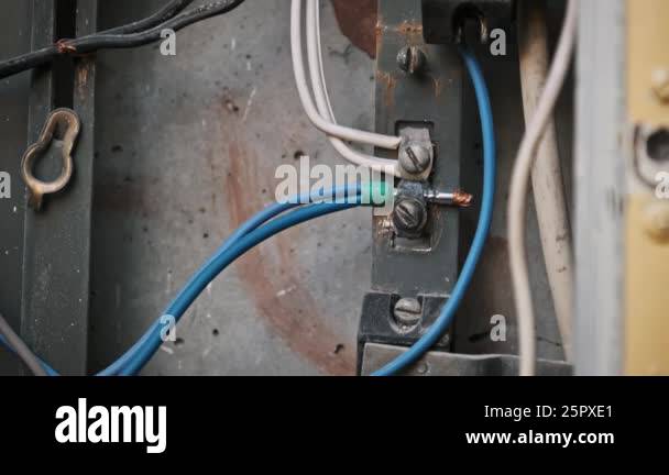 A detailed close-up of electrical wiring connected inside a metallic ...
