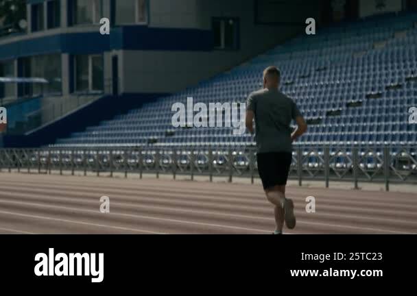 Wide rear slowmo shot of unrecognizable male para-athlete with acheiria ...