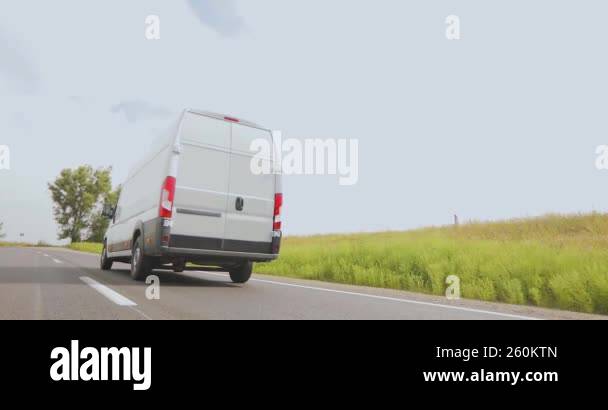 Cargo minibus drives on the highway in sunny weather. White Cargo ...
