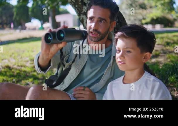 Father son looking binoculars in forest having outdoor adventure ...