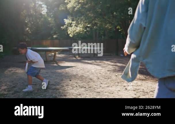 Father son playing frisbee in summer park. Young parent and active child throwing each other ...