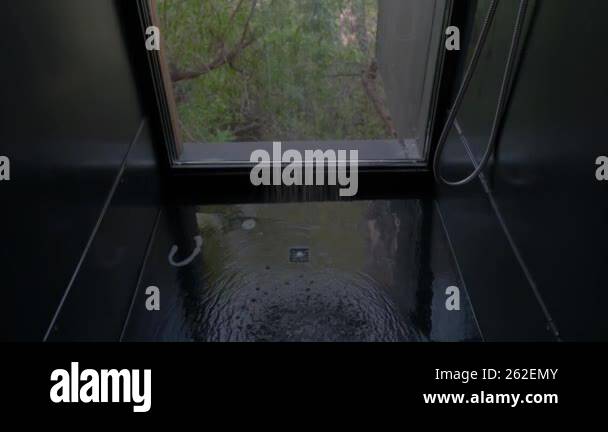 This slow-motion video captures water gently falling in a modern shower ...