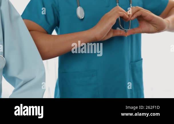 Professional team of medical staff stand in line, raise heart hand ...