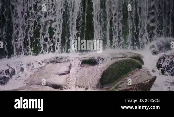 A detailed close-up of a mountain waterfall, showcasing glistening ...