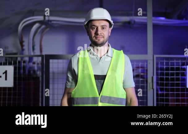 Confident electrical engineer stands with arms crossed in front of ...