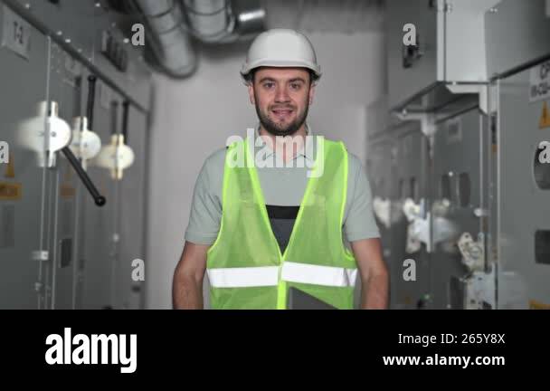 Portrait of electrical engineer with laptop inspects modern electrical ...