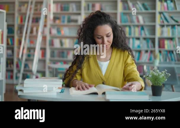 Amazed Hispanic Latino woman female girl library university reading book wow smiling hobby ...