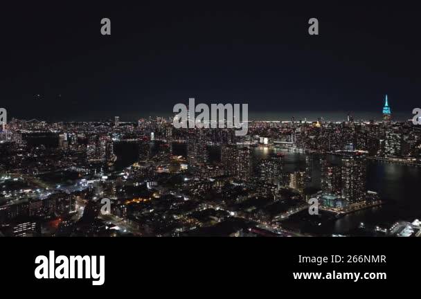 Aerial view of Queens, New York City, skyline at night. Camera pans ...