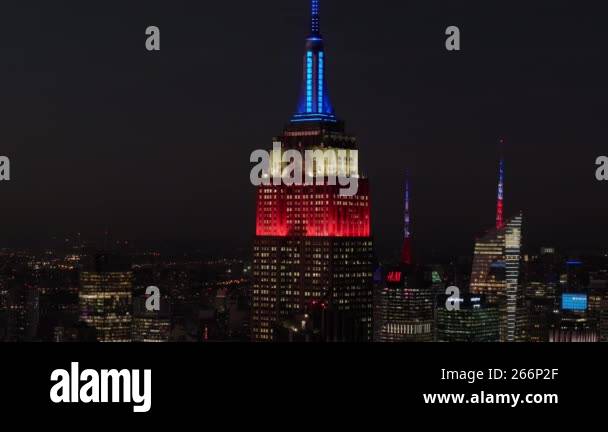 Empire State Building top in Midtown Manhattan displays blu, yellow and ...