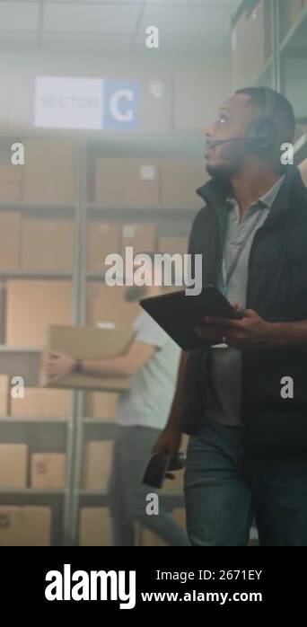 African American Inventory Manager in Headset Scans Cardboard Box with E-Commerce Online Orders ...