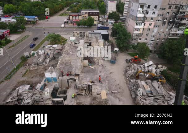 Workers clear debris, oversee demolition process from roof. Crane ...